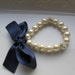 Ivory pearl bracelet with dark navy blue ribbon and rhinestone