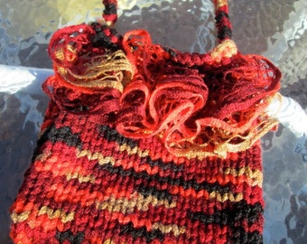 Hand knit bag made with ruffled yarn in shades of red, tan and black ...