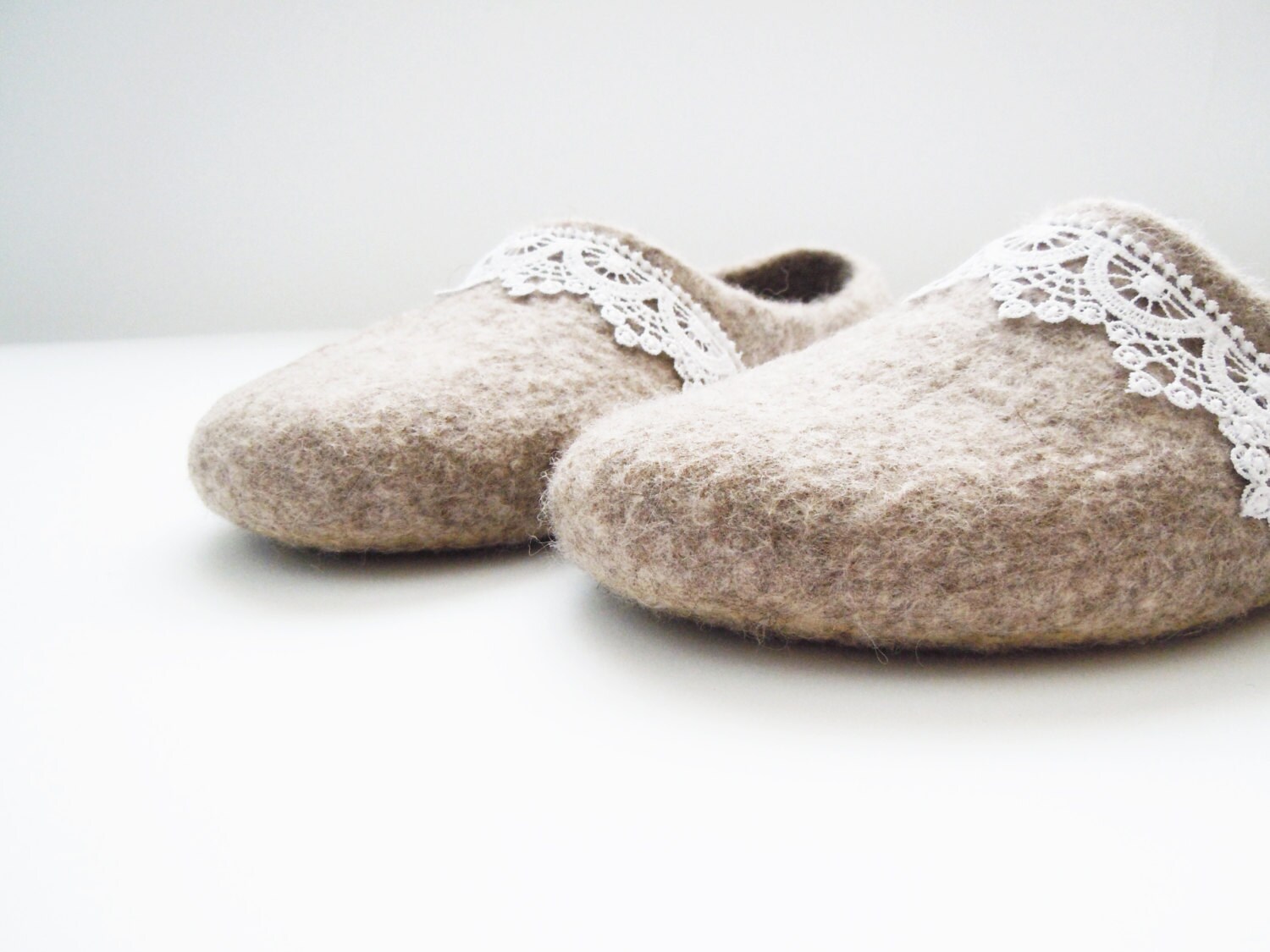 Felted women slippers decorated with lace.