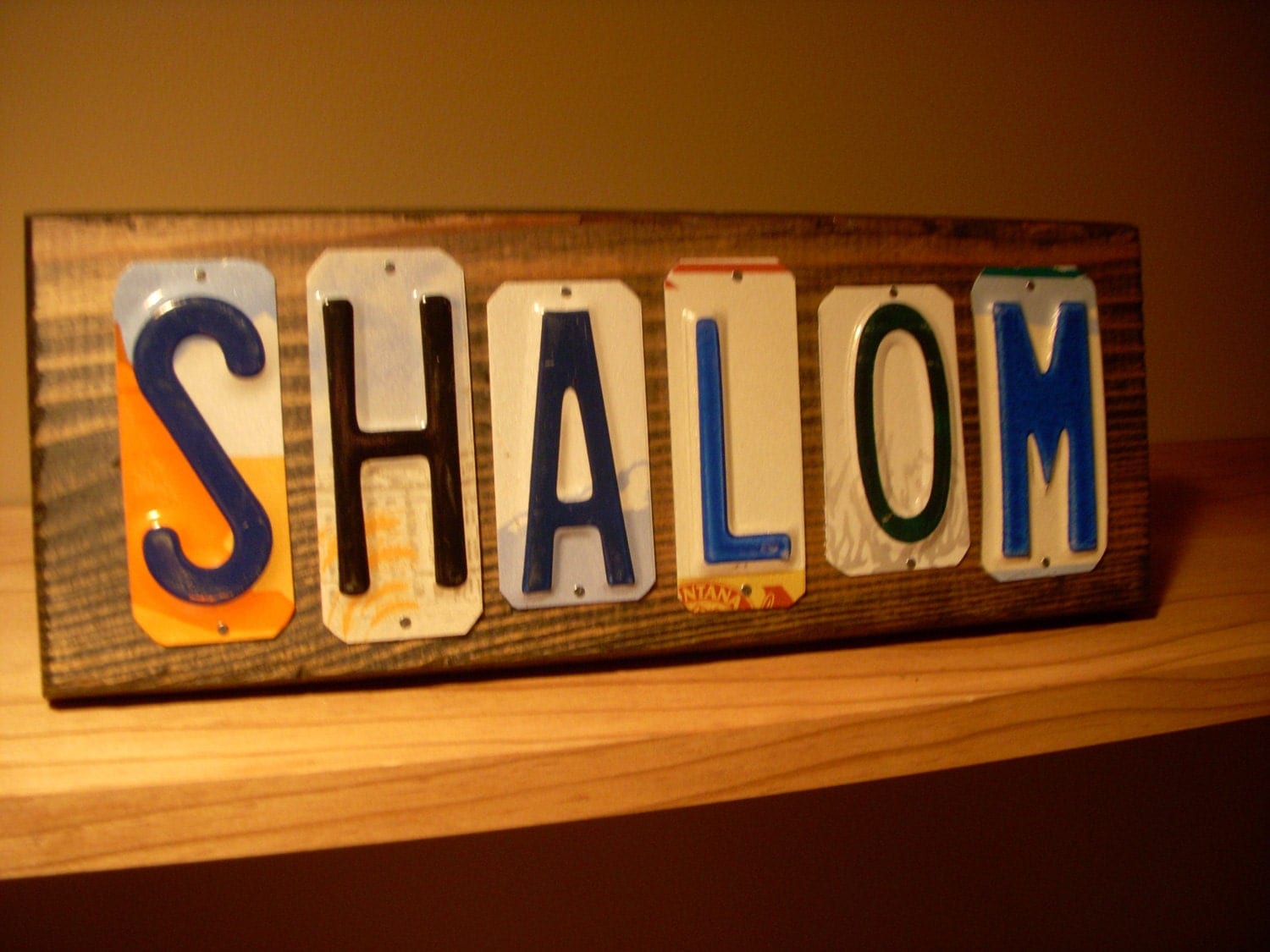 Shalom wall sign made from recycled license plates.