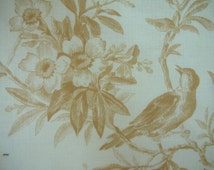 Light brown toile fabric with birds. Background is cream color.