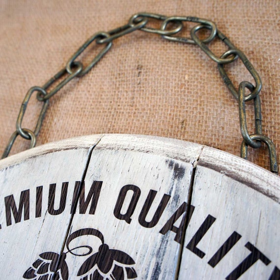 Distressed wooden barrel end sign with engraved artwork