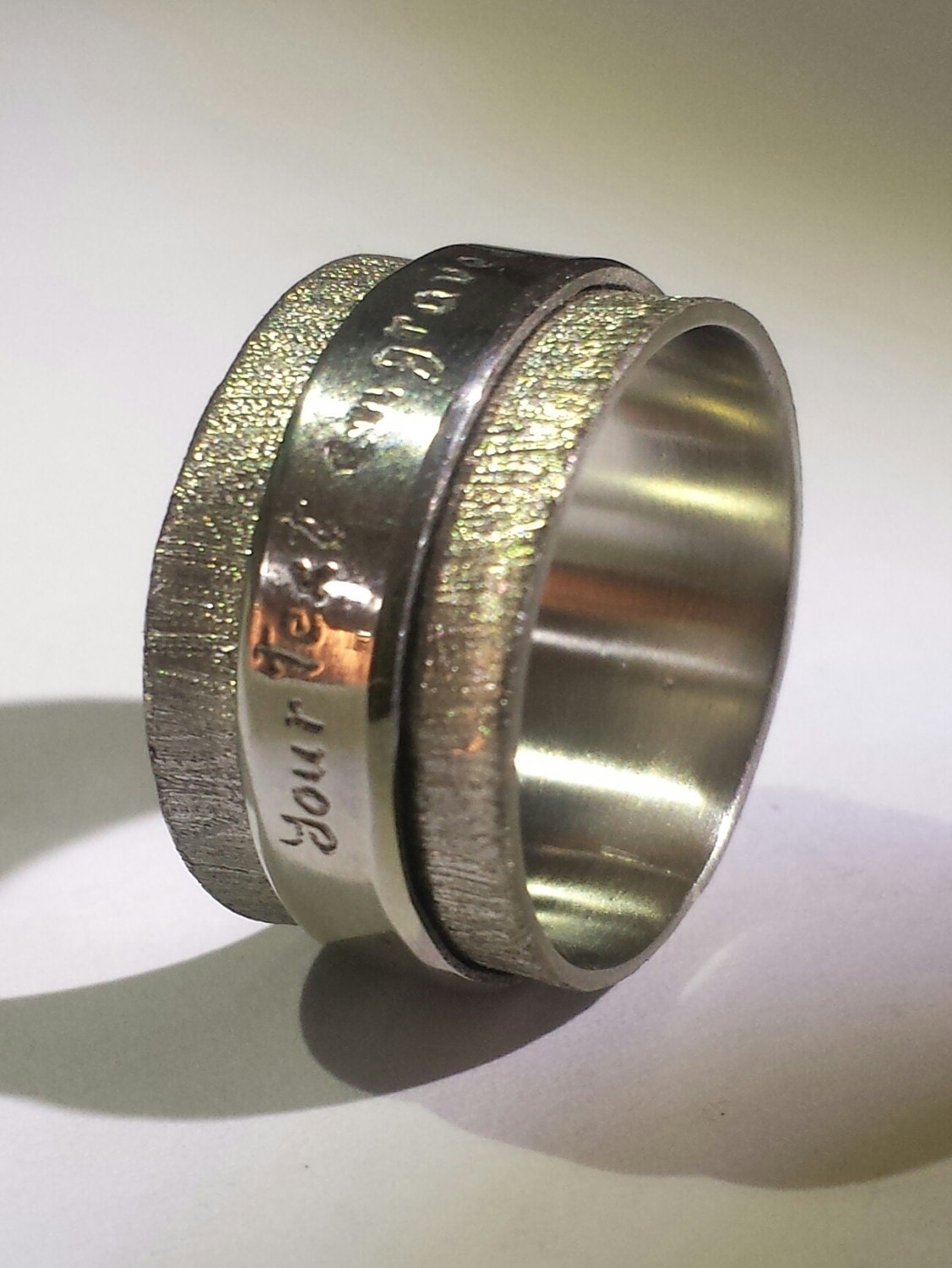 Silver ring with engraved personalized text.