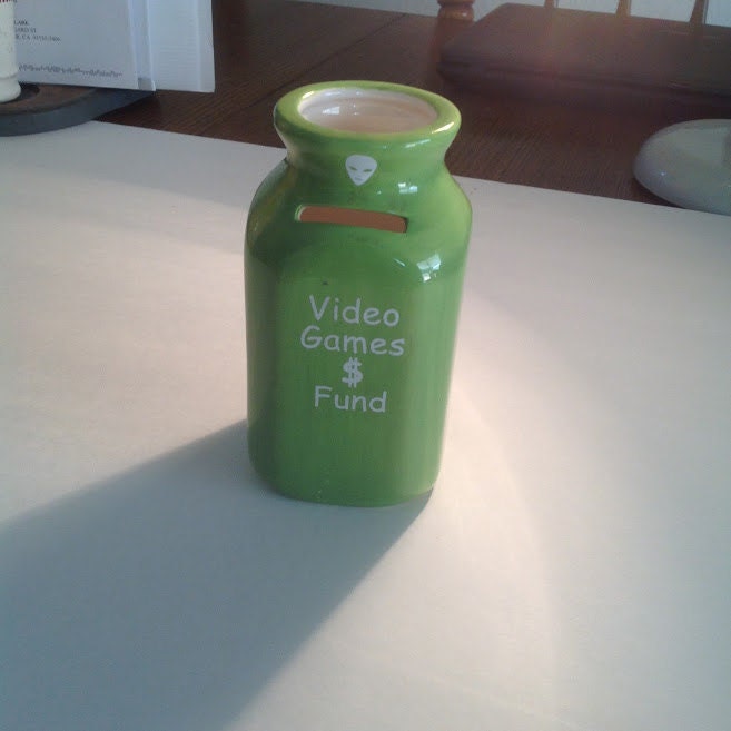 Little green (men?) video game vase with a UFO design around the rim ...