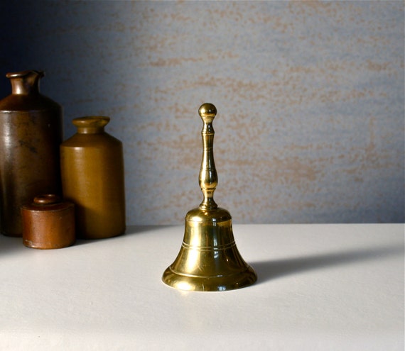 Small brass hand bell. A vintage solid brass dinner bell.