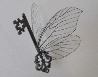 Flying magical key with large butterfly wings in antique brass