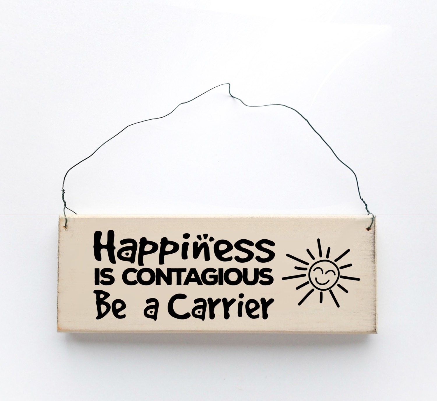 Wood sign saying Happiness is Contagious Be A