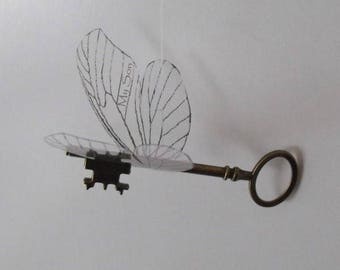 Magical flying key with large butterfly wings in shiny silver